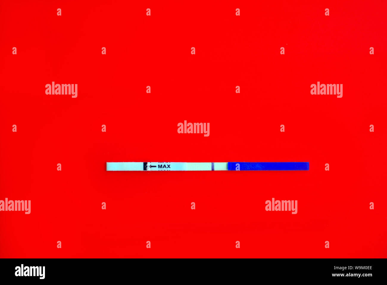 The test a strip on pregnancy with negative result on a red background ...