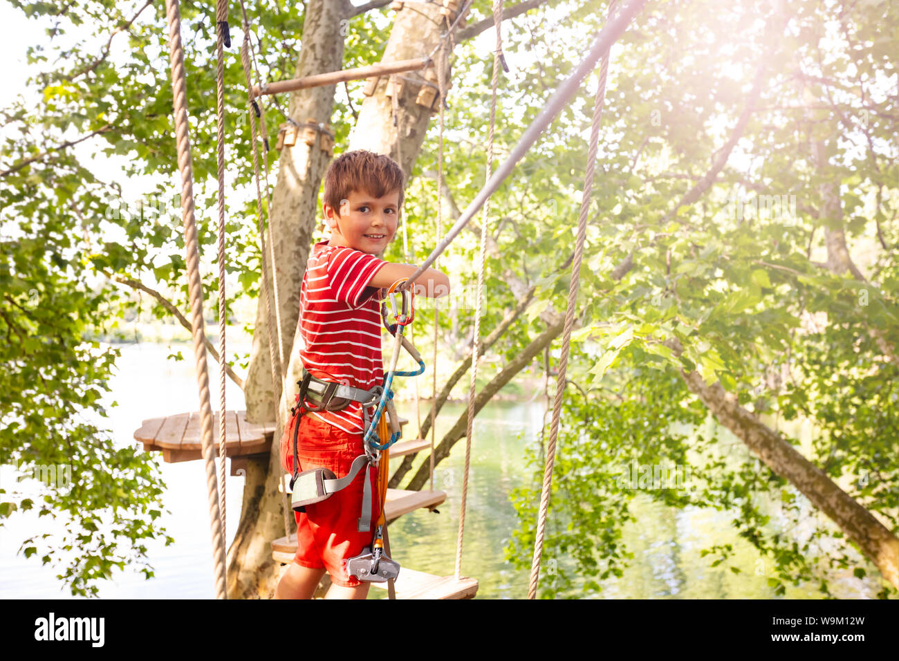 Happy boy portrait on the rope bridge between tree Stock Photo - Alamy
