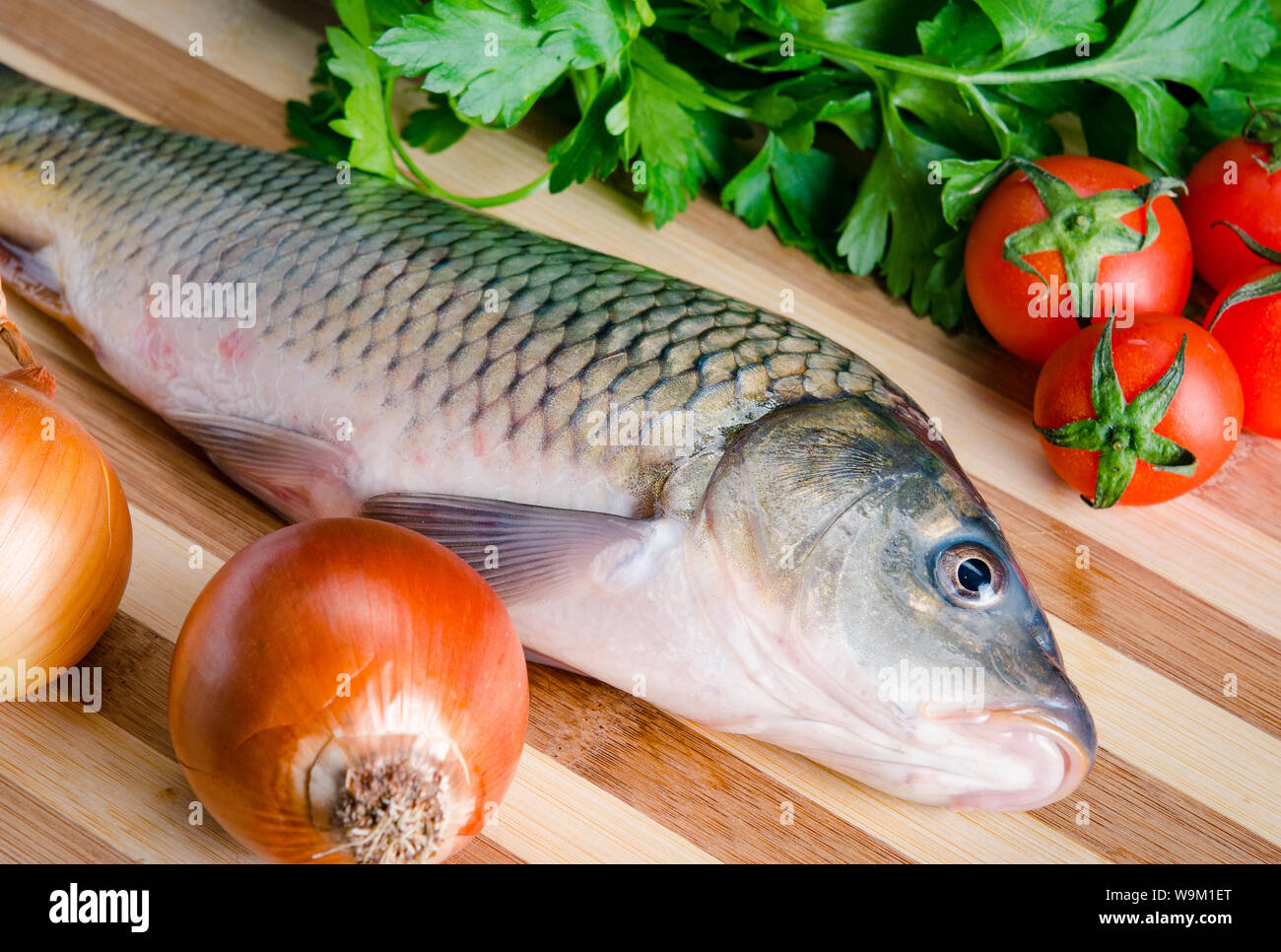 The uncooked fish on cutting board in meal preparation concept Stock ...