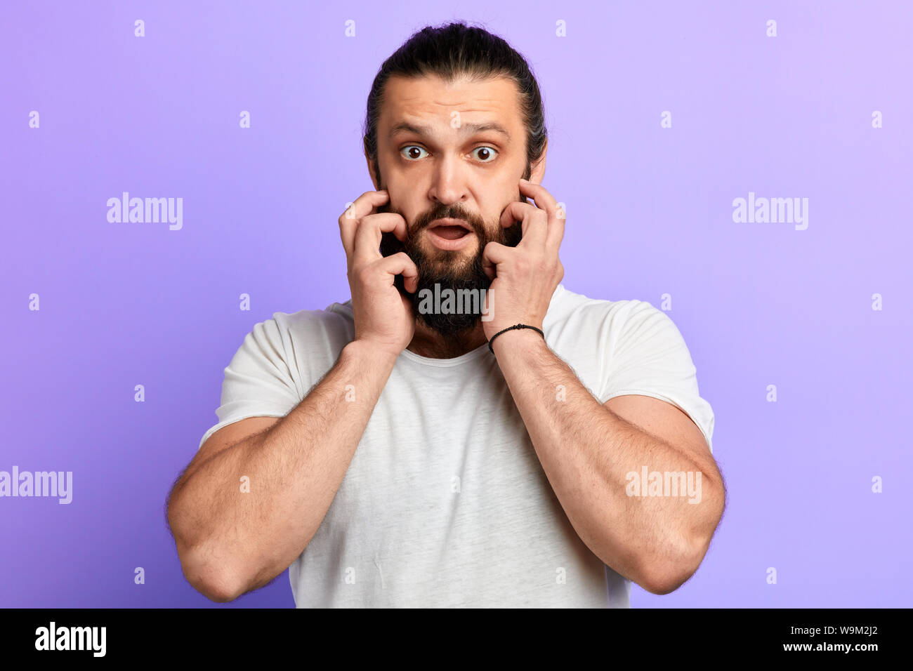 emotional man with scared and anxious expression,touching his face with ...
