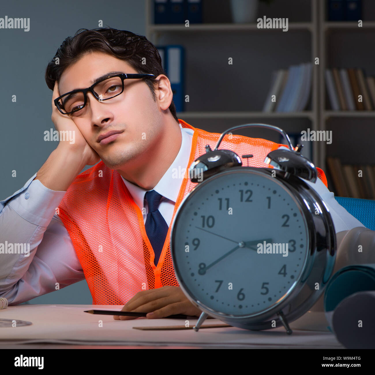 Tired architect working late long hours under stress to meet deadline ...