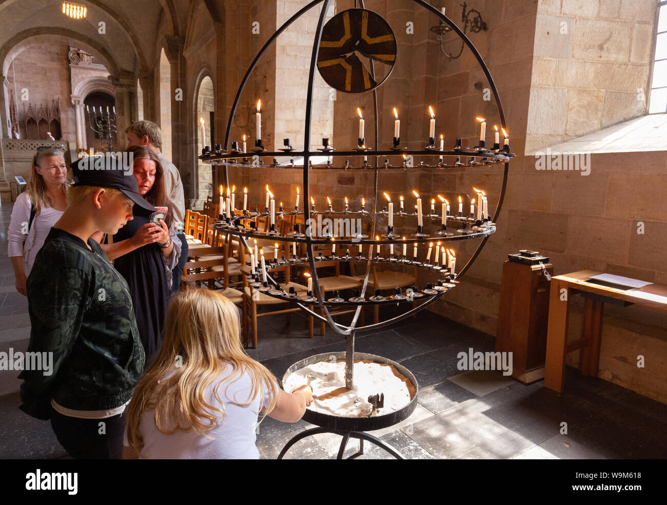 Family lighting candle in church; Lund cathedral interior, Lund, Sweden ...