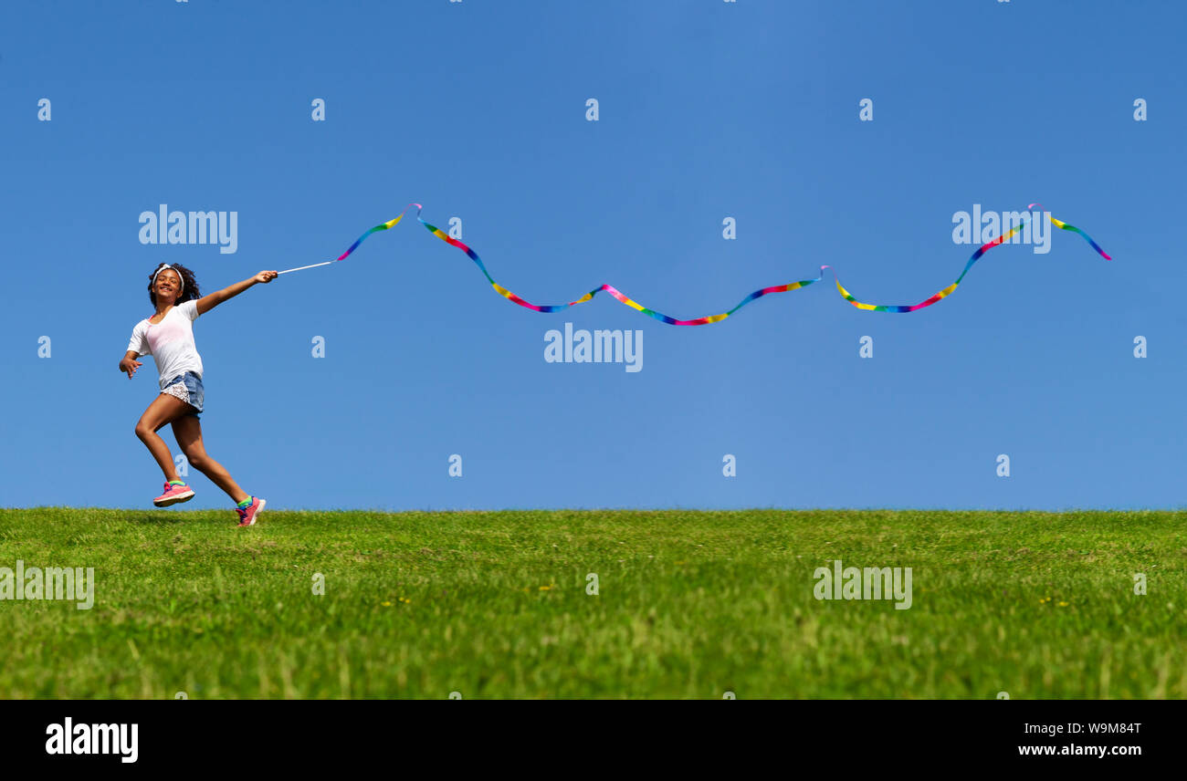 Cool fun girl run and wave with long color ribbon Stock Photo - Alamy