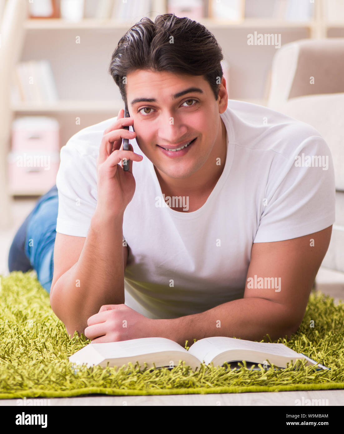 The man reading book at home on floor Stock Photo - Alamy