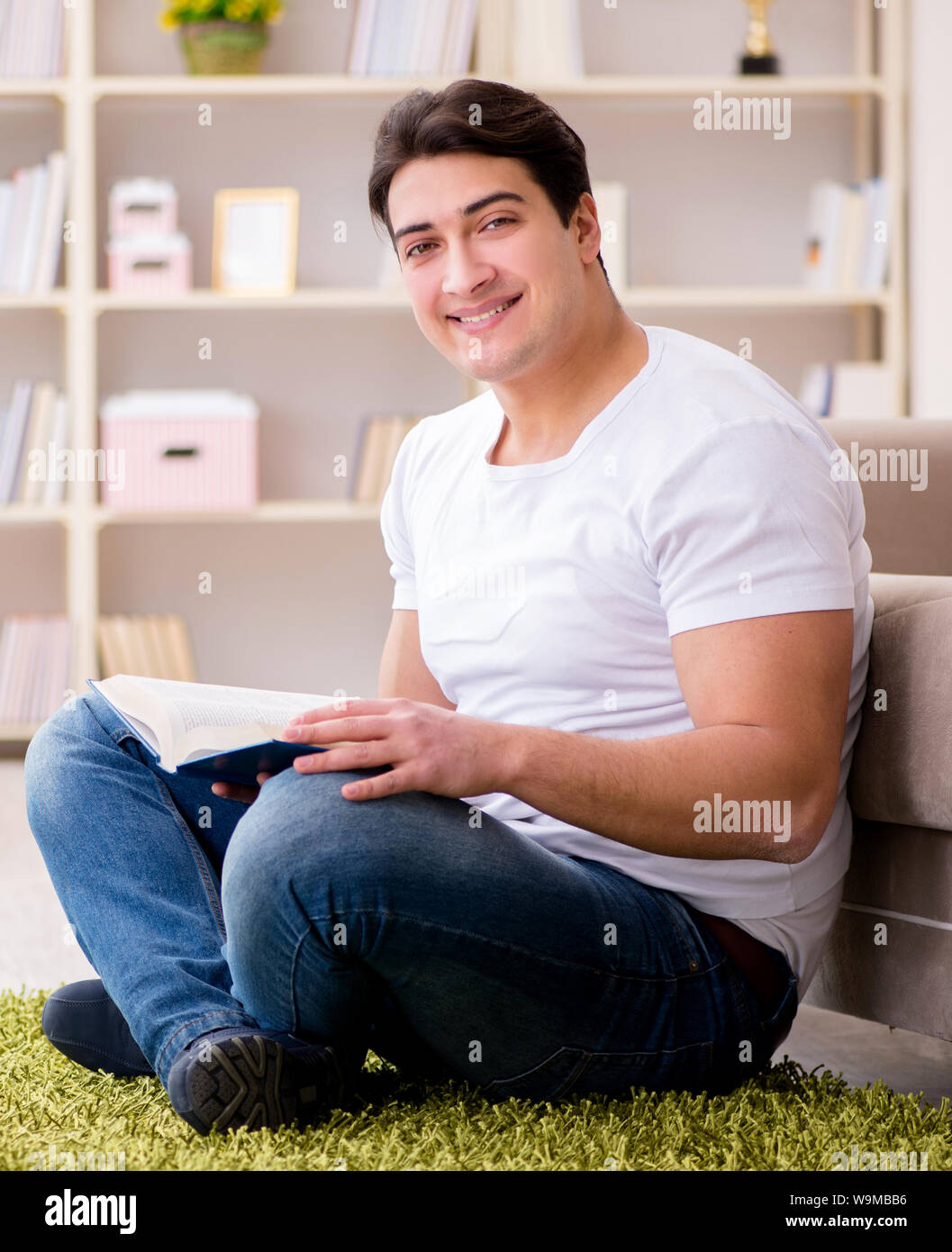 The man reading book at home on floor Stock Photo - Alamy