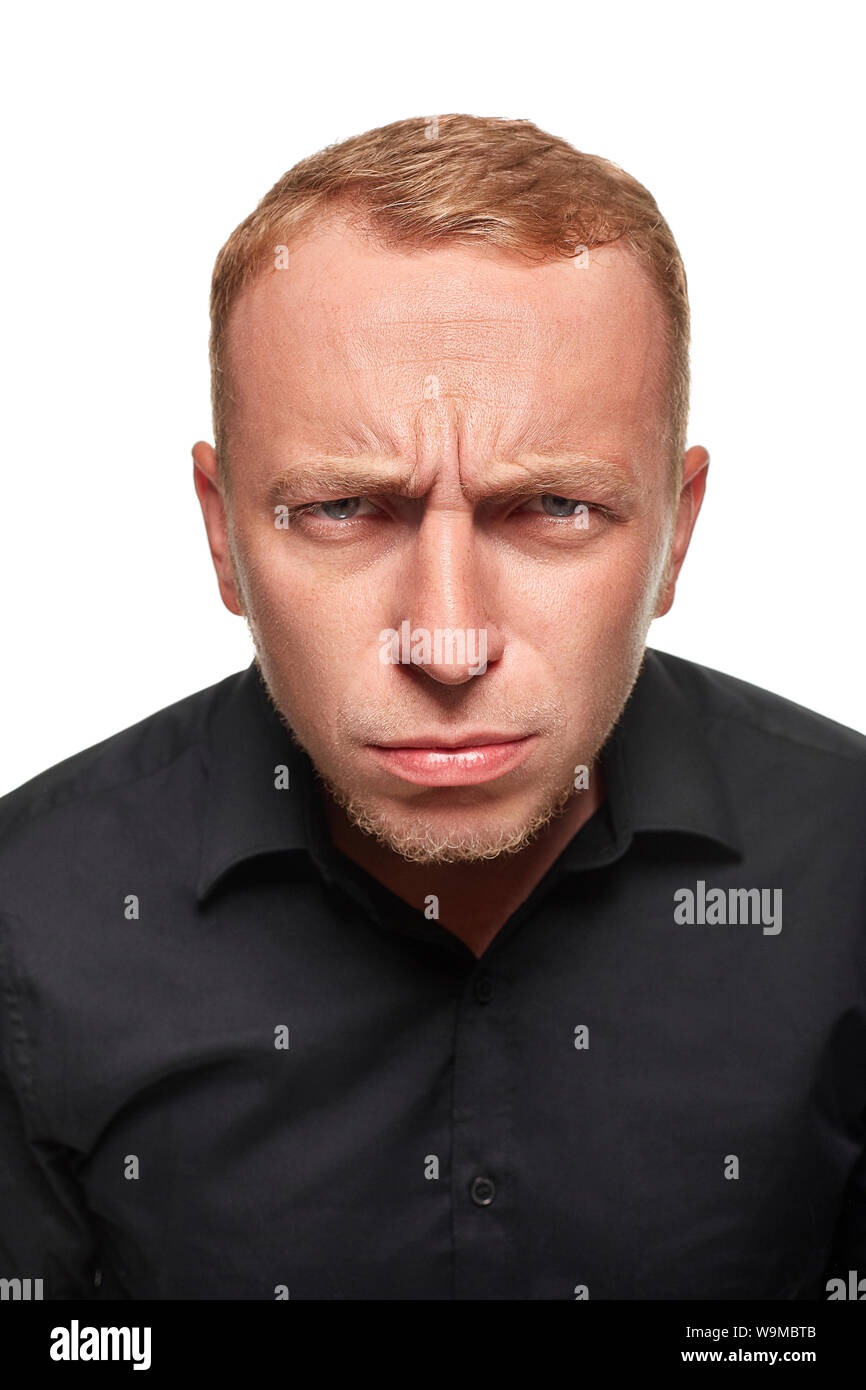 Portrait of young man questionably mistrustfully looking with lowered ...