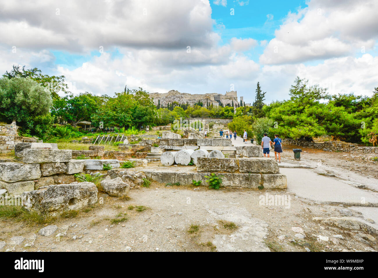 Tourists walk through the ancient Greek Agora at the base of Acropolis ...