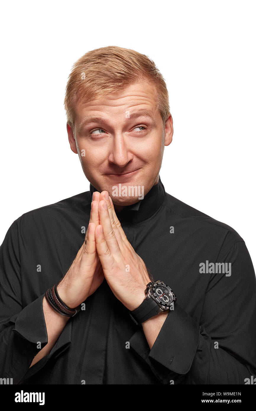 Smiling young man keeping hands together. Cunning handsome guy planning ...
