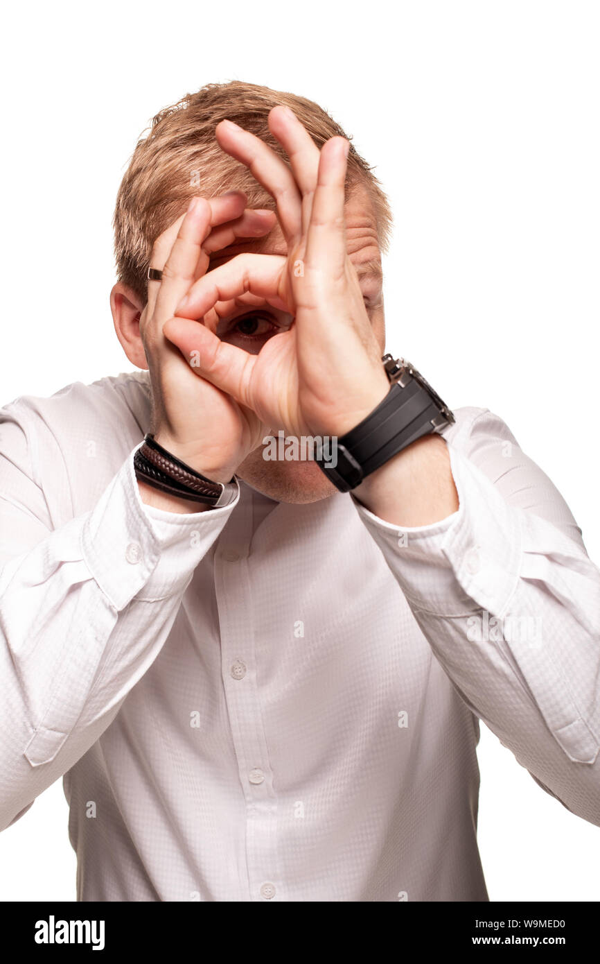Imposing, young, blond man in a white shirt is grimacing while standing ...