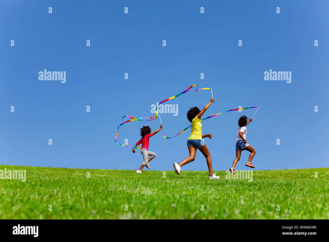 Children running very fast wave with color ribbons Stock Photo - Alamy