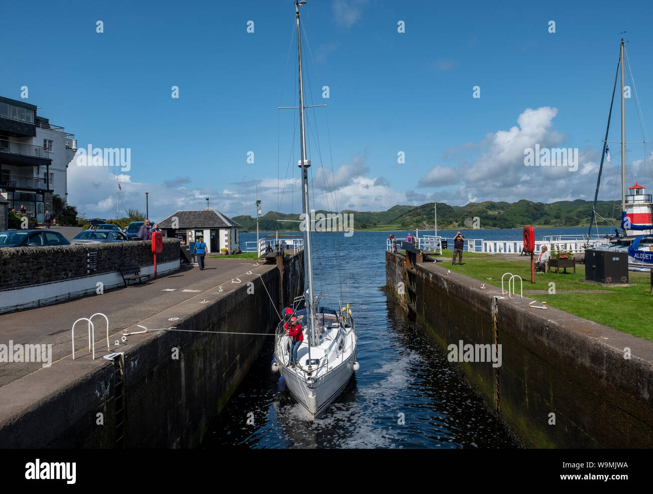 A yacht enters the sea lock at the entrance to the Crinan canal at ...