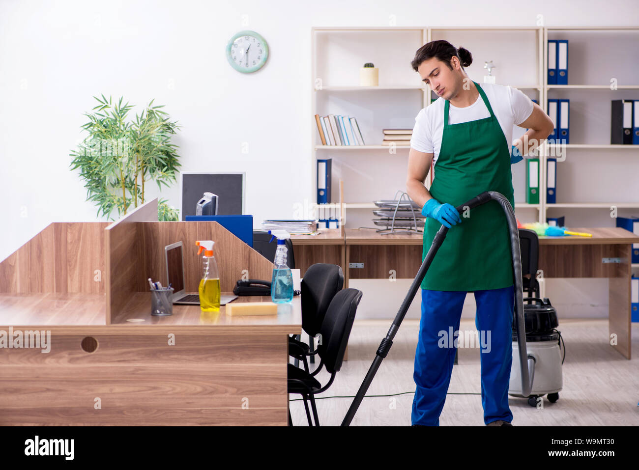 The young handsome contractor cleaning the office Stock Photo - Alamy