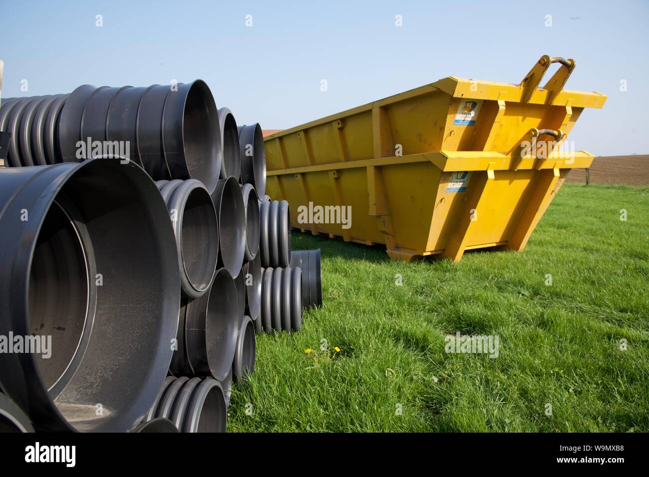 large bore pipes and waste skips dropped on site in preparation for a ...