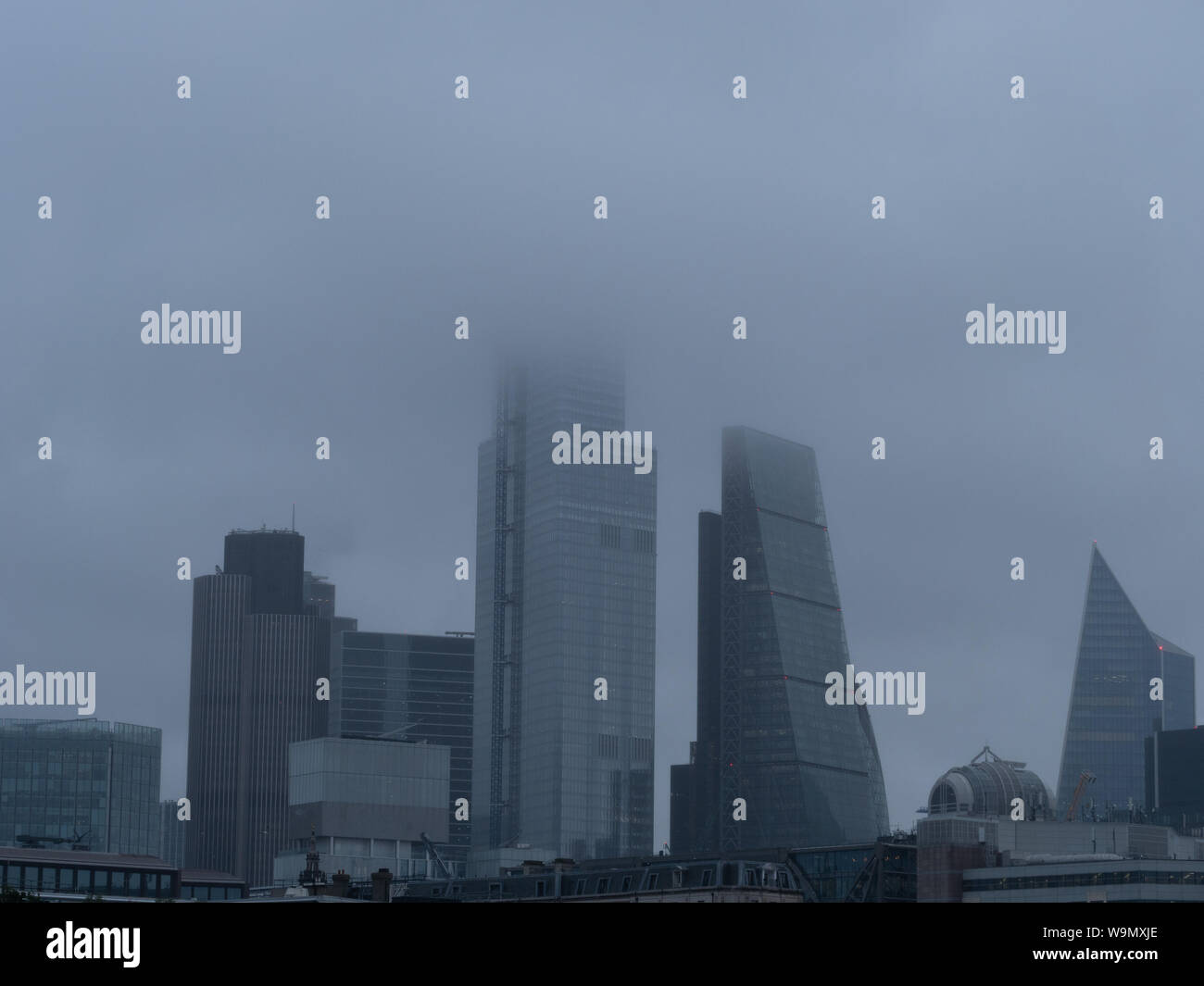 Rain clouds covering the top of tall buildings hi-res stock photography ...