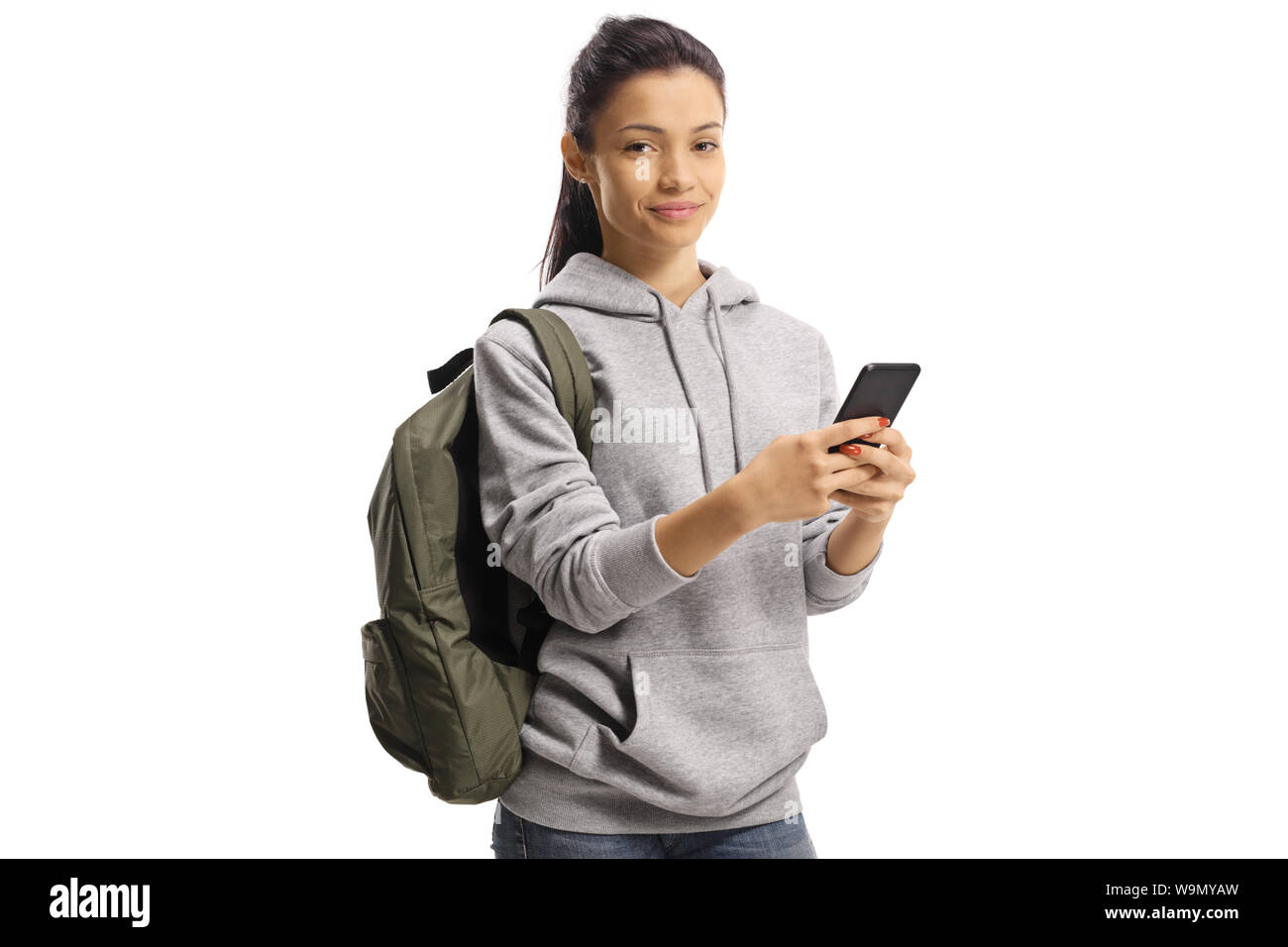 Cheerful female student holding a mobile phone and looking at the ...