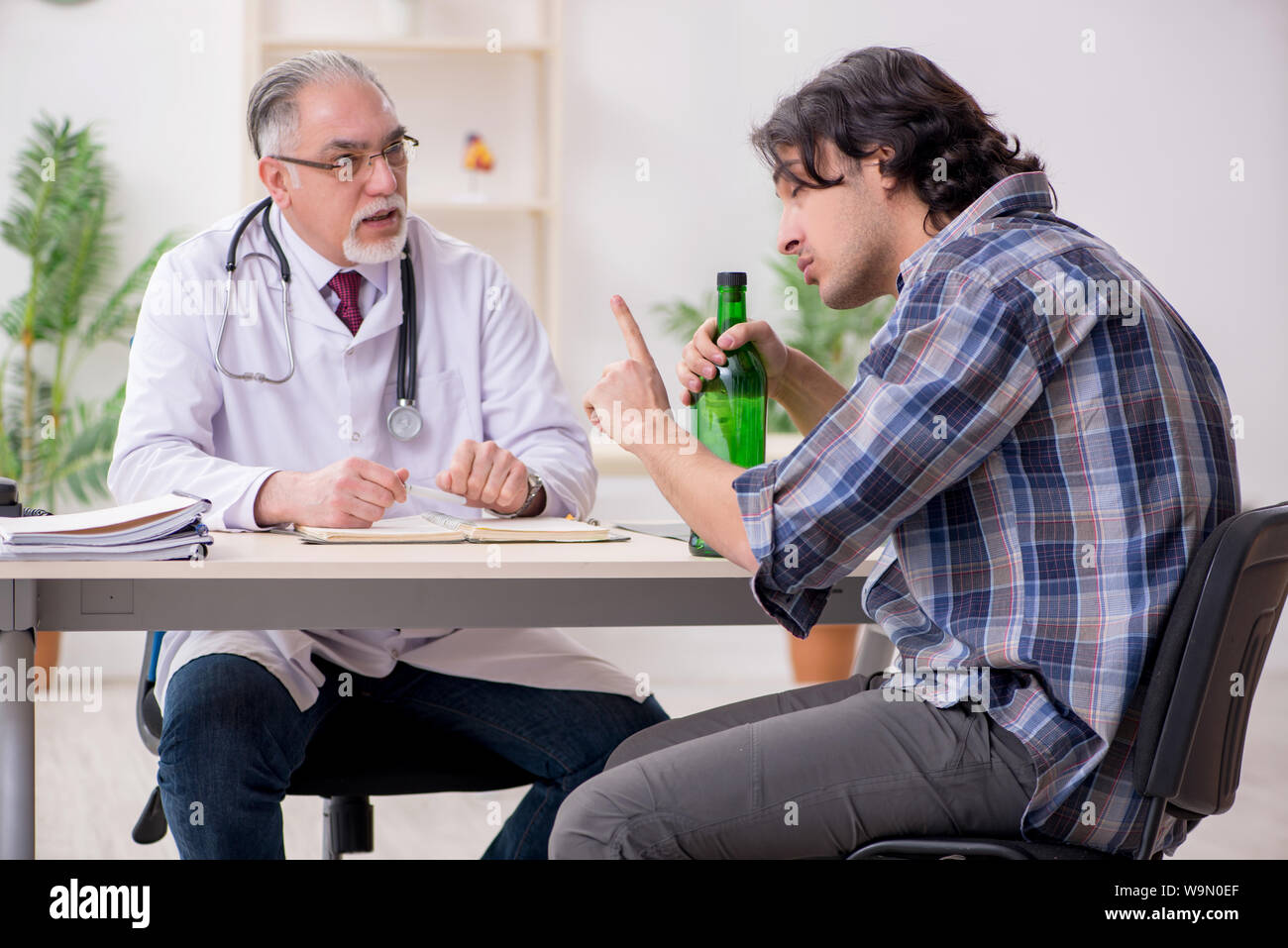 The young male alcoholic visiting old doctor Stock Photo - Alamy