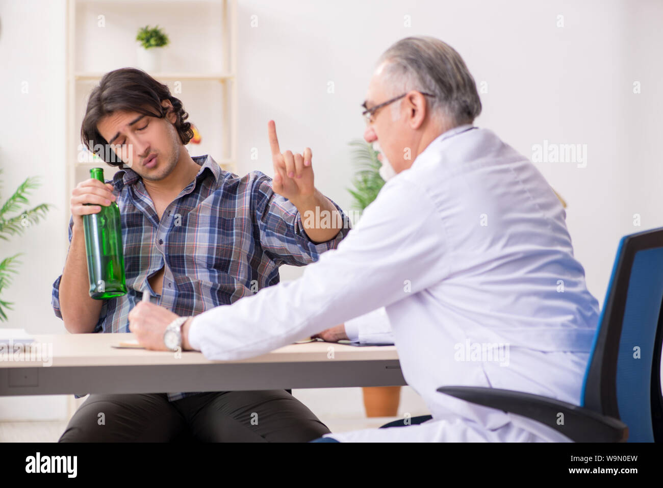 The young male alcoholic visiting old doctor Stock Photo - Alamy