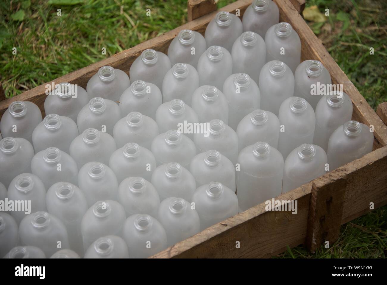 Glass bottles: identical glass bottles contained within a wooden crate ...