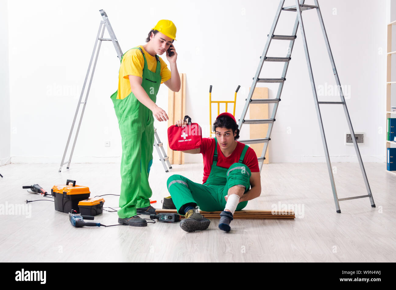 The injured worker and his workmate Stock Photo - Alamy