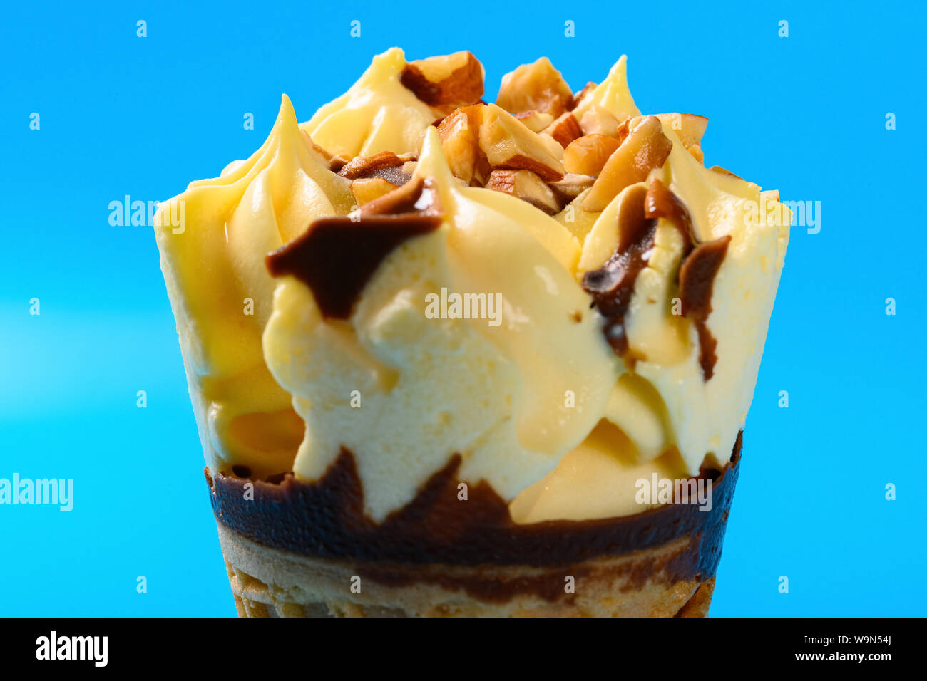 close up of mango and chocolate flavor ice cream cone with peanut on ...