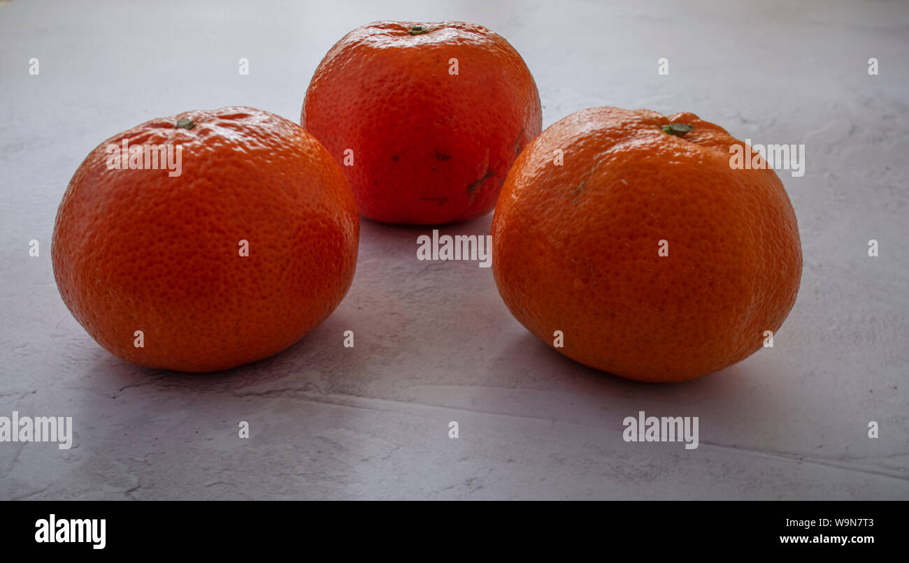 Food photography - side view of three large mandarins on a plain white ...