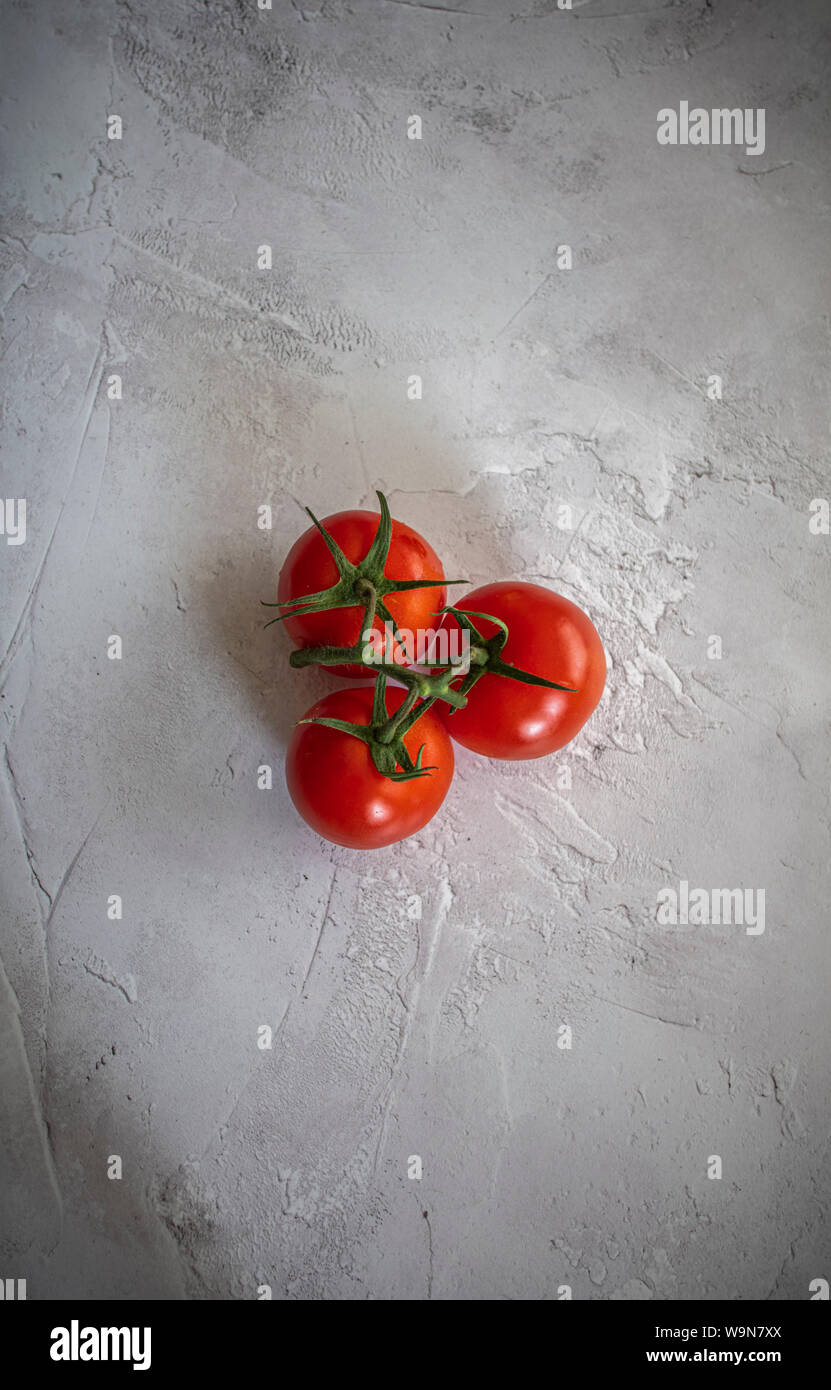 Food photography - Three red tomatoes on the vine - view from above ...