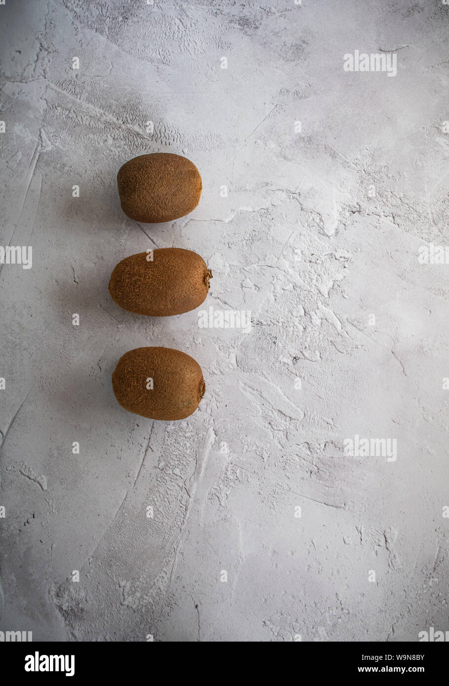 Food photography - overhead view of three kiwin fruit on a plain white ...