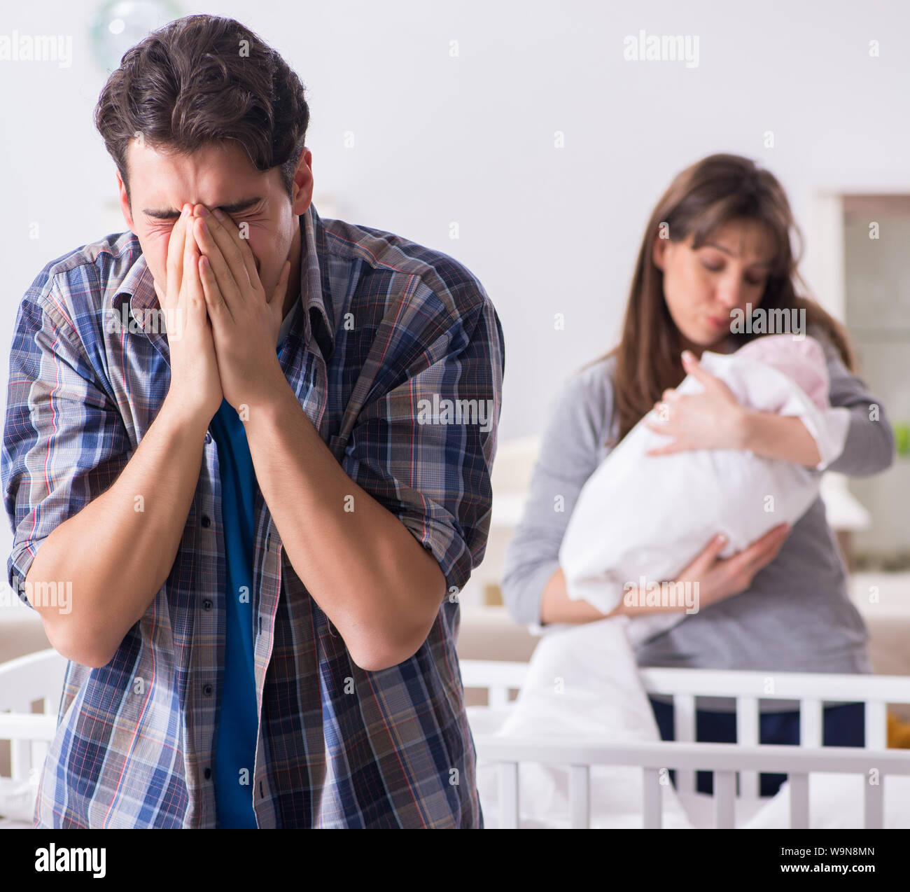 The young dad cannot stand baby crying Stock Photo - Alamy