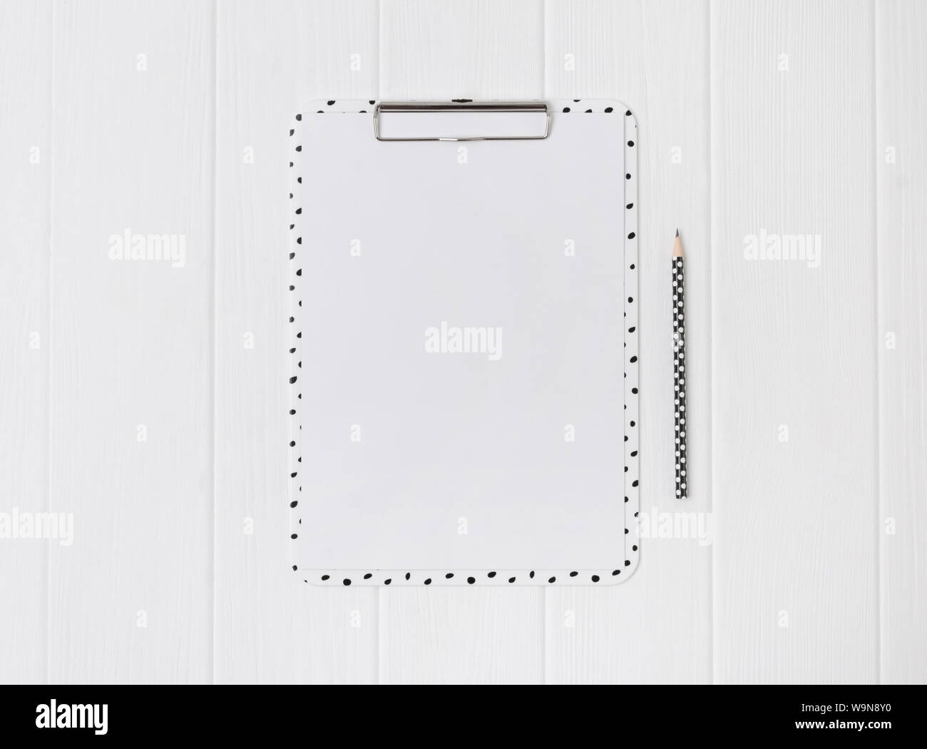 Modern clipboard with blank sheet and pencil on a white wooden ...