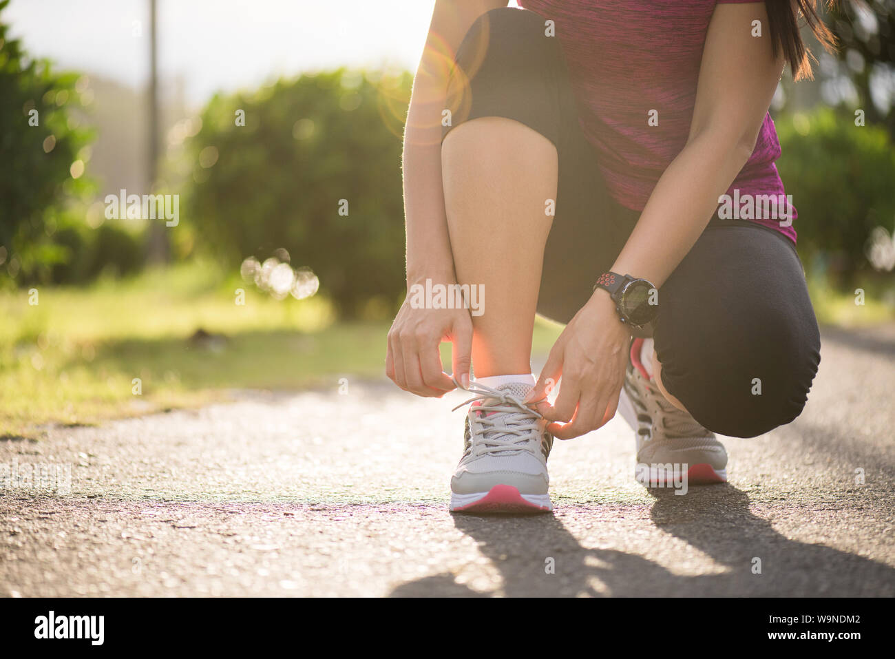 Running shoes - closeup of woman tying shoe laces. Female sport fitness runner getting ready for ...