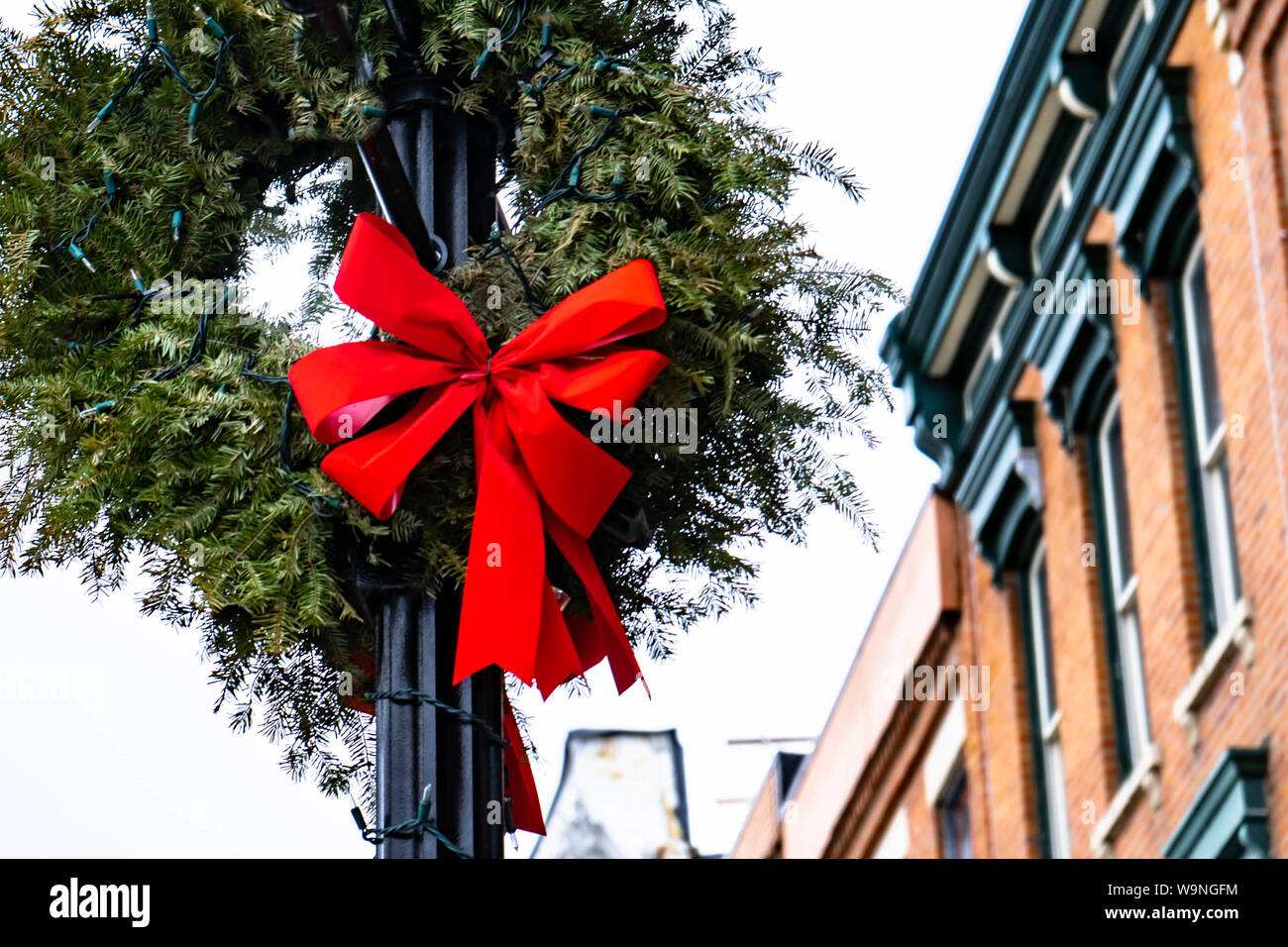 christmas wreath with garland and bow hanging on lantern pillar with ...