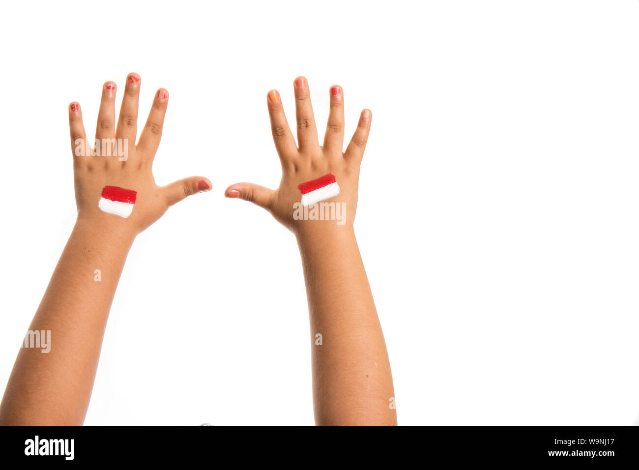 young girls hands only with the Indonesian flag painted on her hands ...