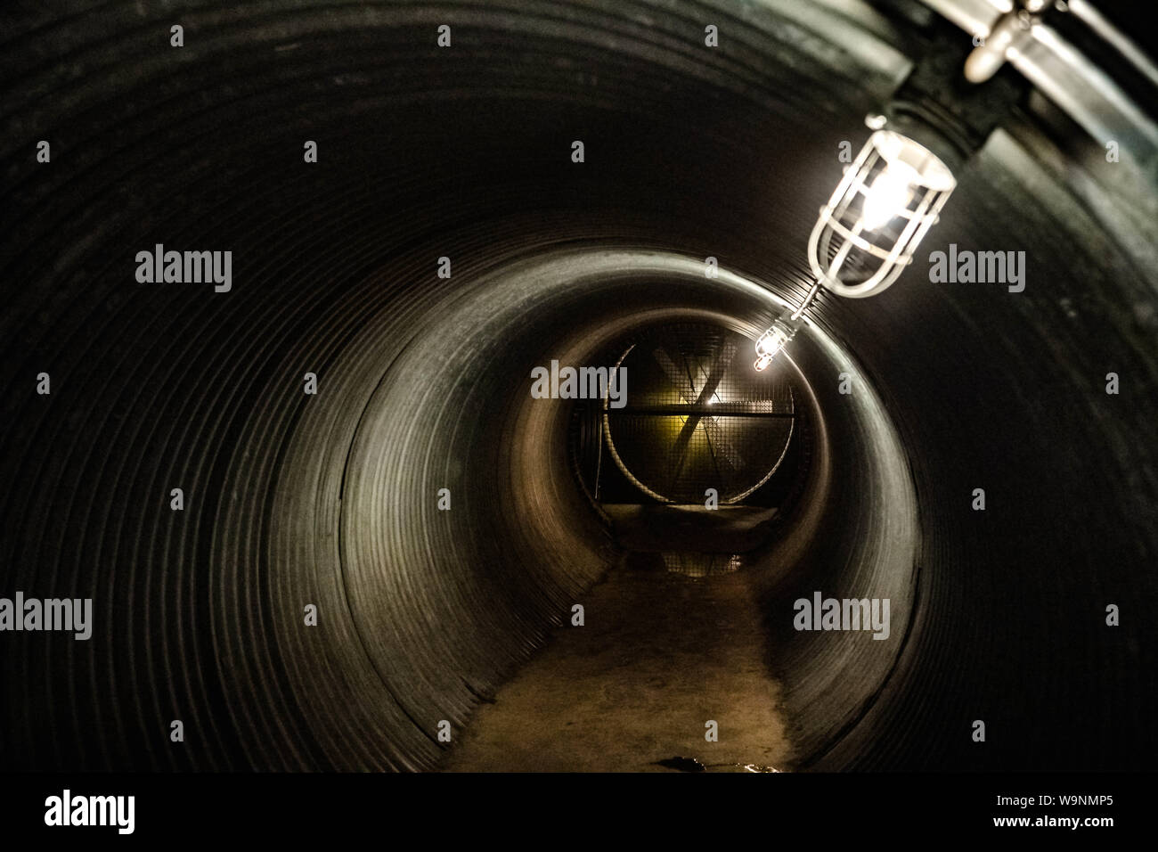 dark and scary underground steel utility tunnel with electricity ...