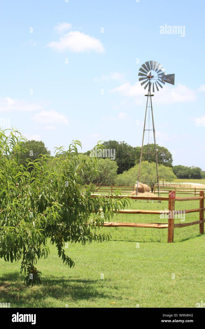 Rustic Ranch with windmill and fence Stock Photo - Alamy