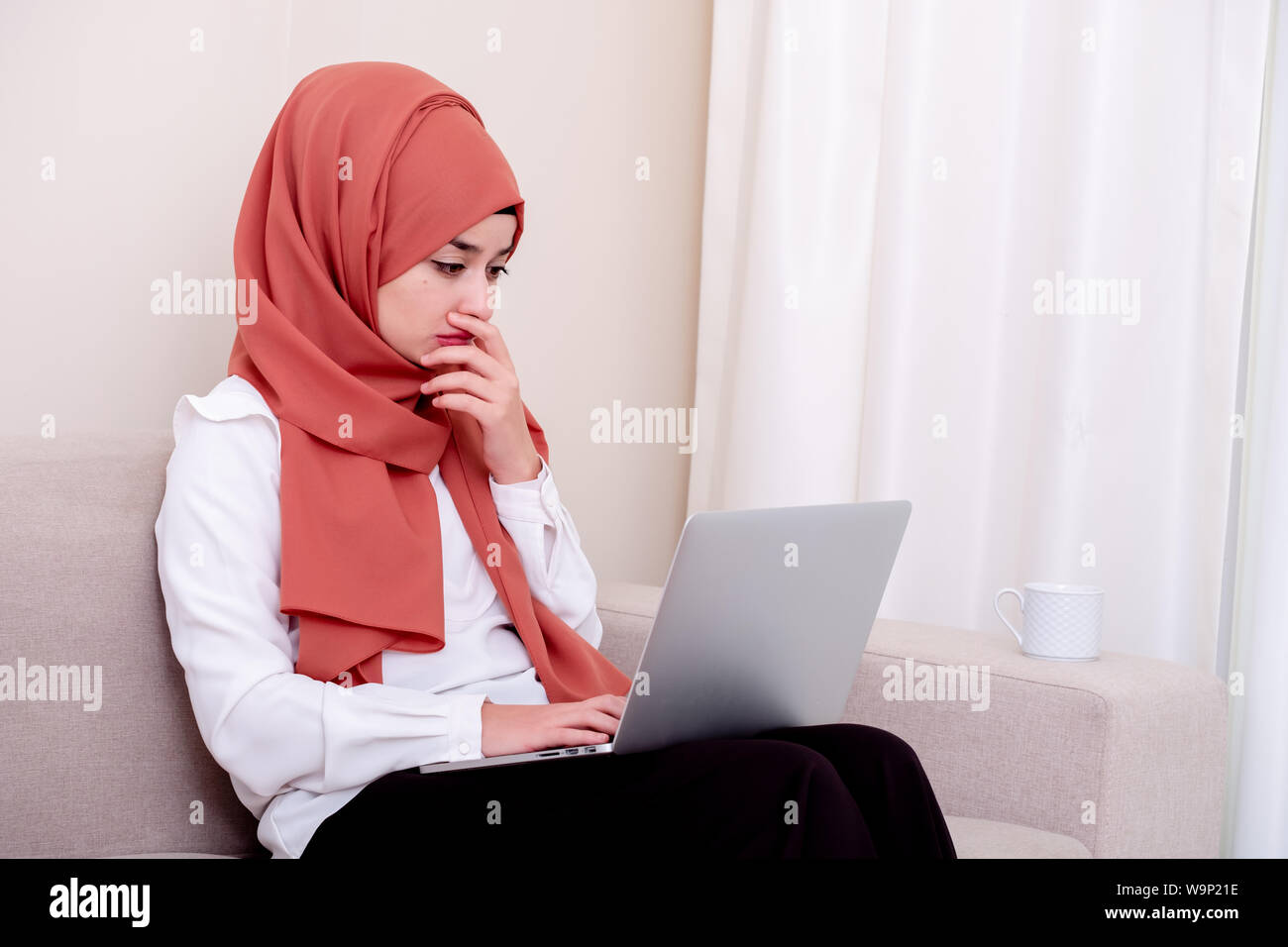 Muslim woman using computer for work and she thinking Stock Photo - Alamy