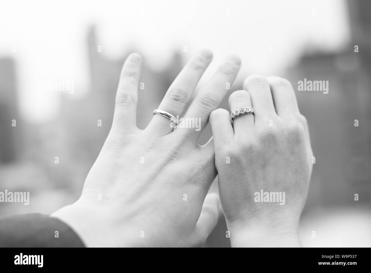 Hands of a newly married couple showing their rings in a roof top in ...