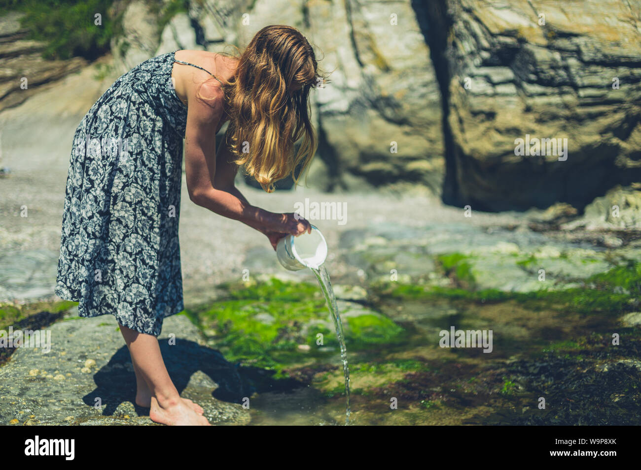 Woman emptying bucket water hi-res stock photography and images - Alamy