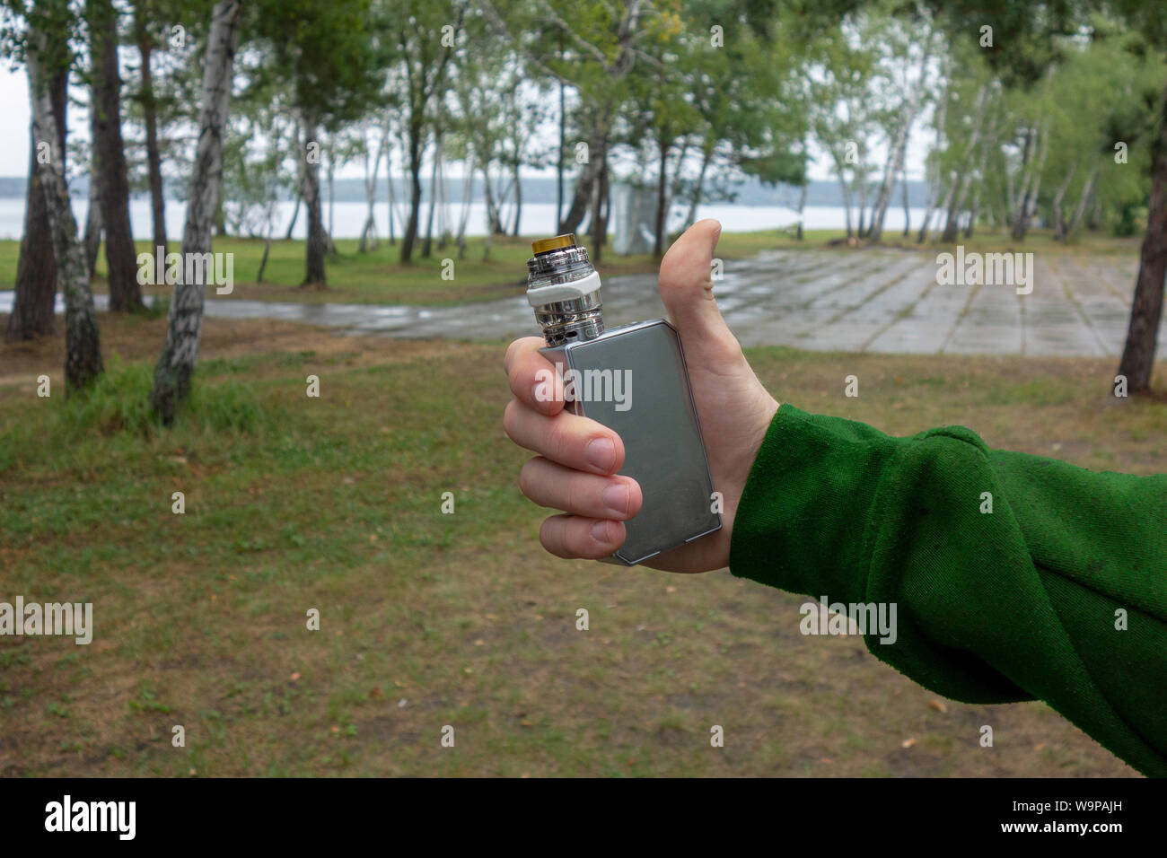 Vaporizer in hand. Man holds vape e-cigarrete device with thumbs-up ...