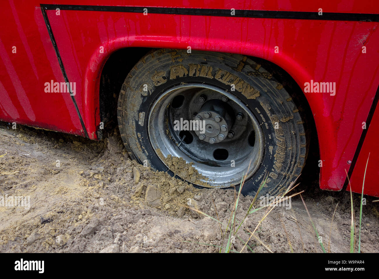 Kharkiv, Ukraine, August, 2019 Bus wheel is bogged down in sand. Red ...