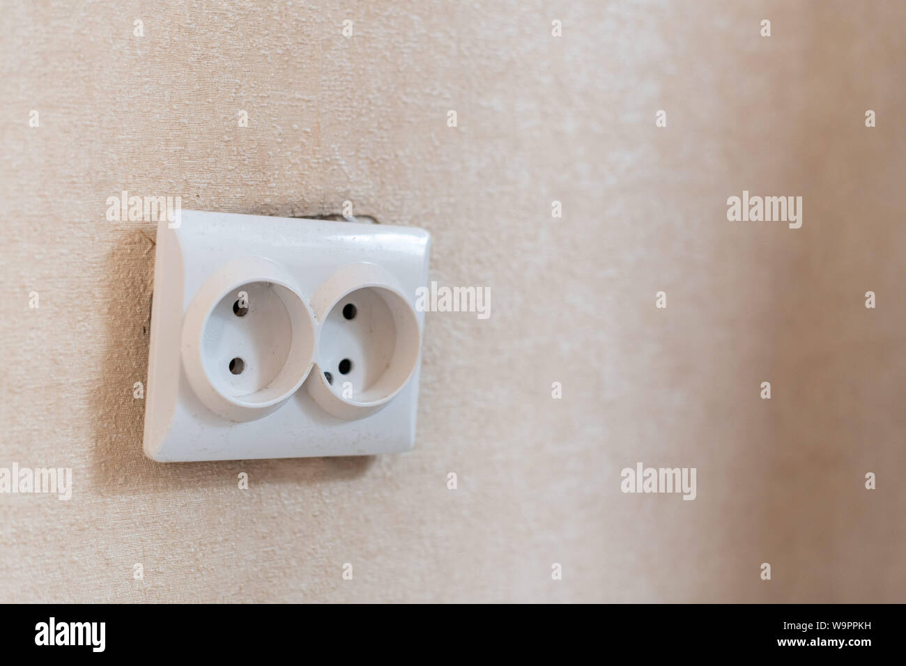AC power double socket on wall, bad incorrectly installed, copy space ...