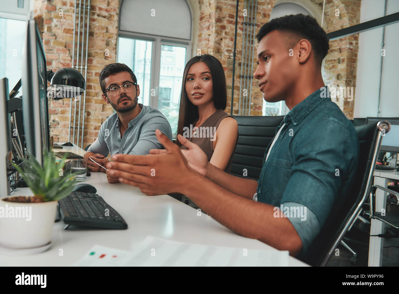 Project result. Multi ethnic team discussing business while working ...