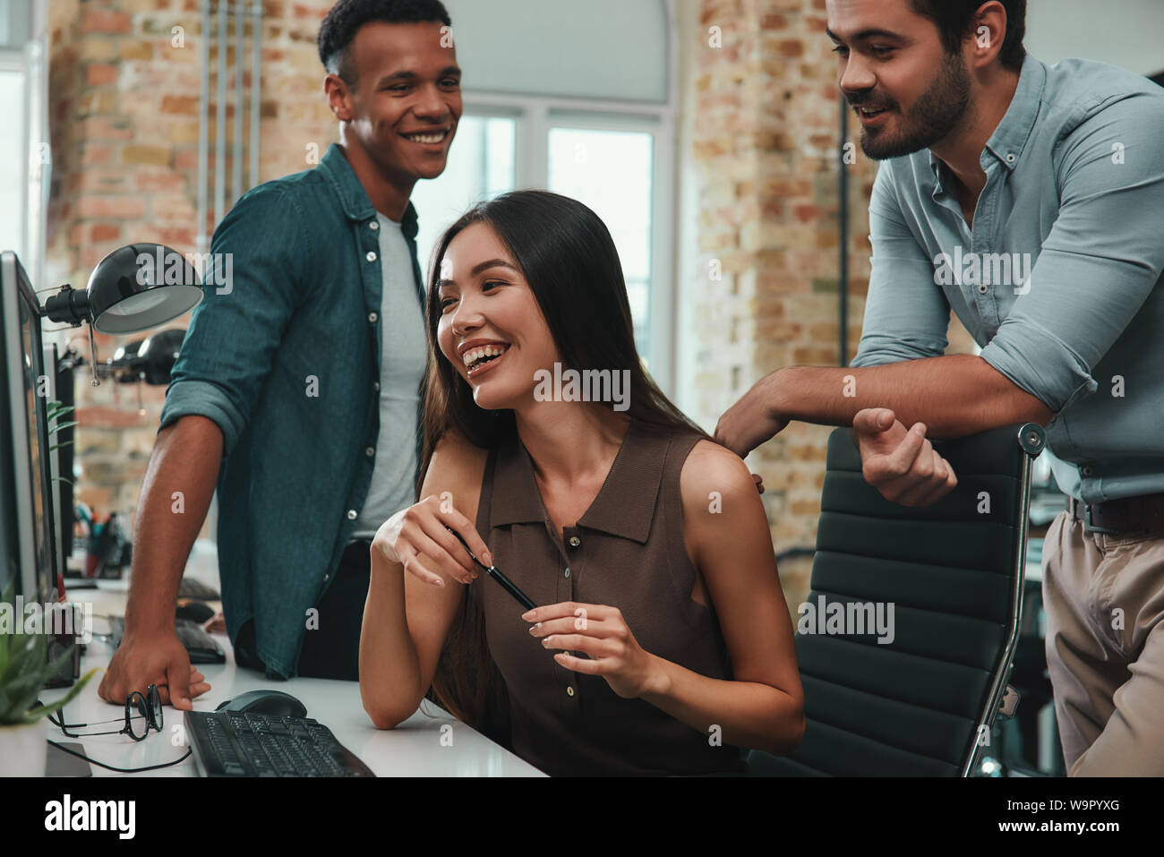 Perfect teamwork. Group of young and cheerful three people discussing ...