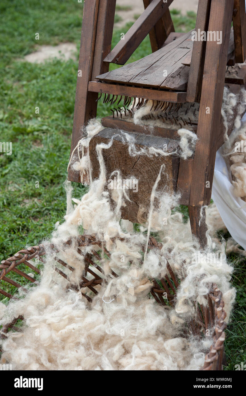 Carding raw wool with an ancient wooden machine Stock Photo - Alamy