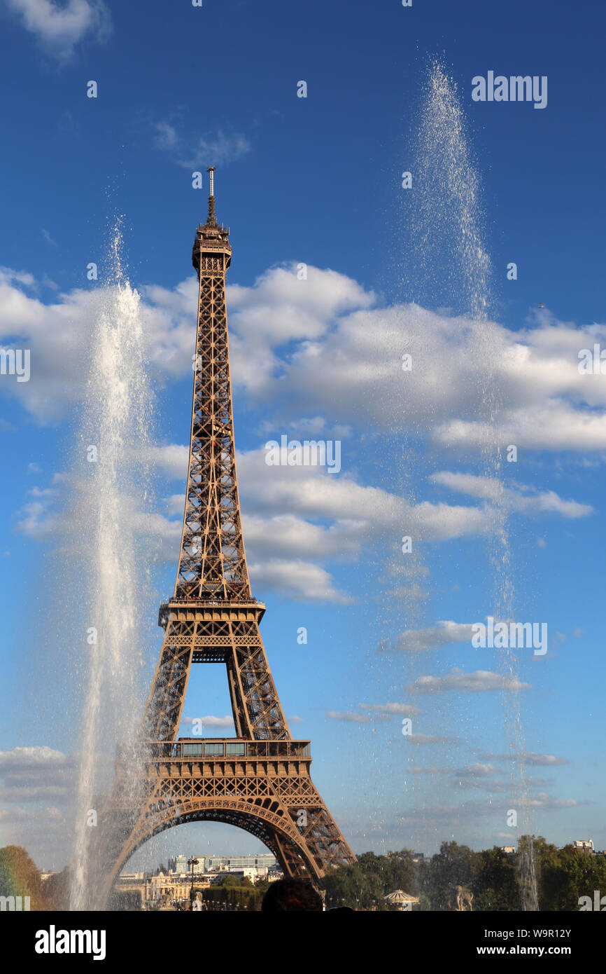 water of Fountain and the Big Eiffel Tower on the blue sky with clouds ...