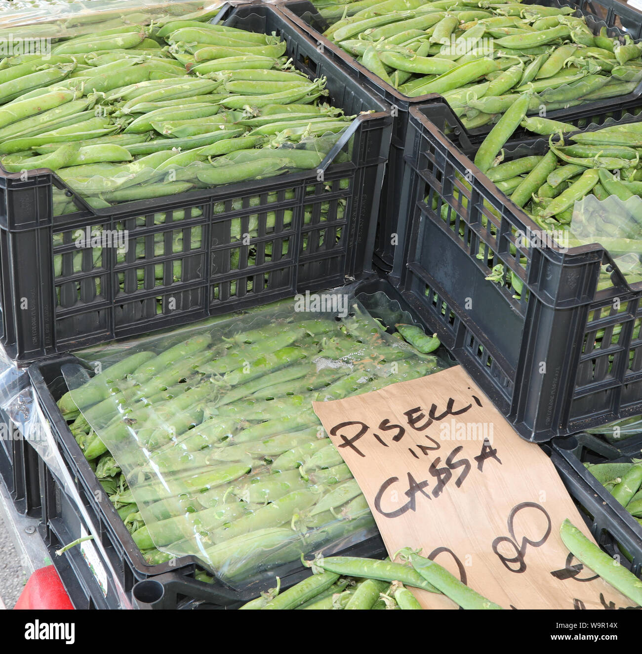 boxes of green peas for sale at italian market. The text means Peans in ...