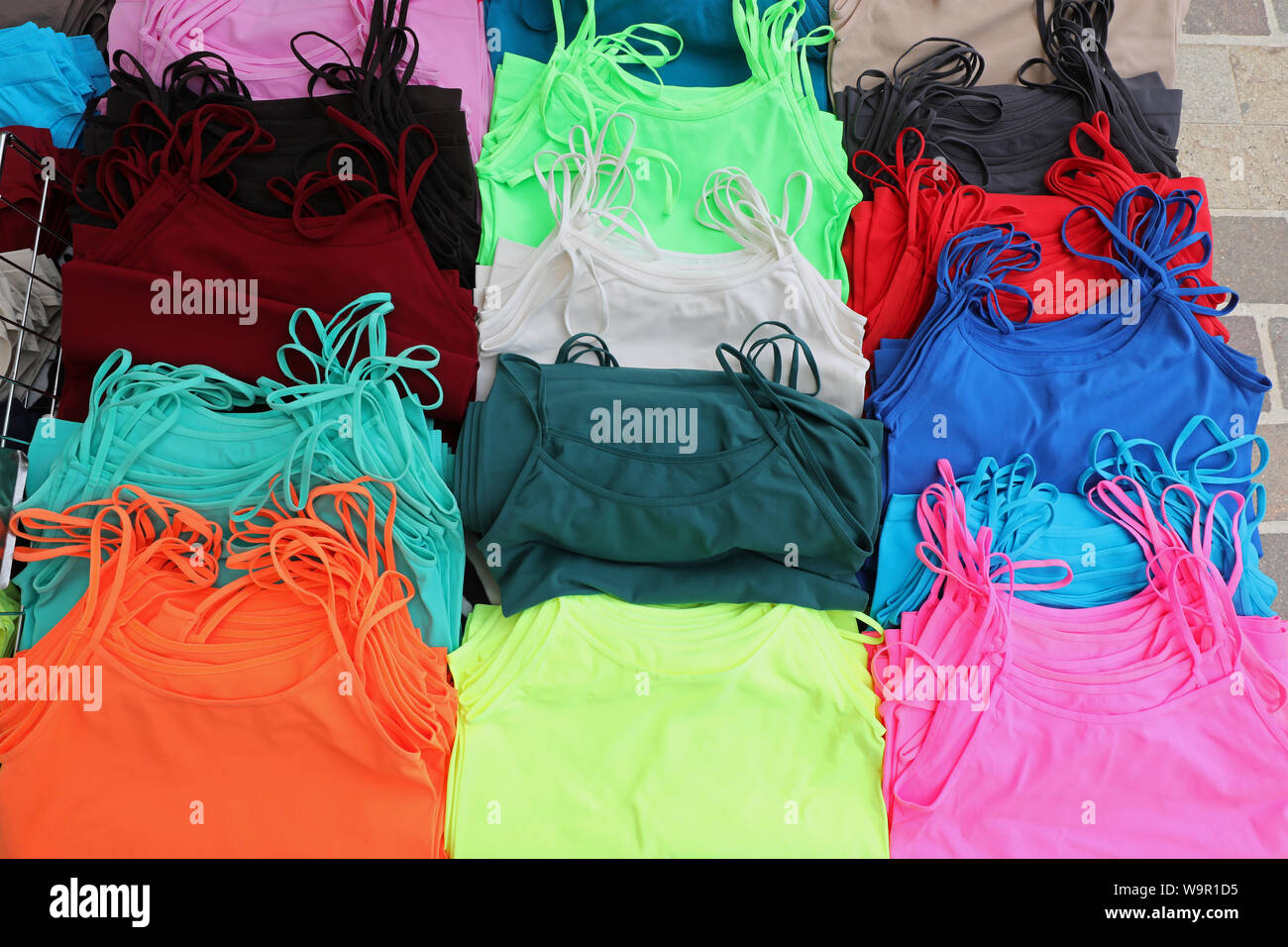 many colored tops displayed in a street market stall Stock Photo - Alamy