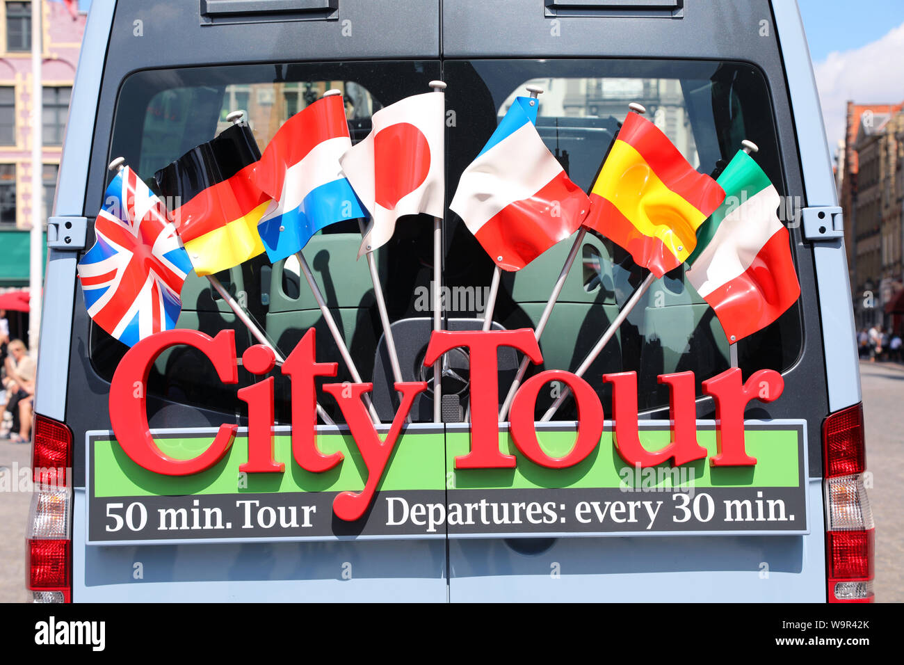Sign with international flags on a City Tour sightseeing bus, Bruges ...