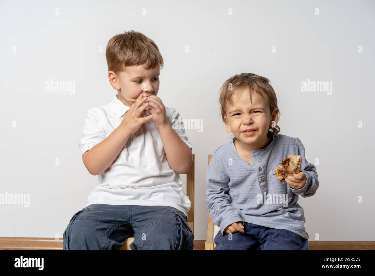 Children indoors eating pizza, being unhappy. Bad piza this time. Pizza ...