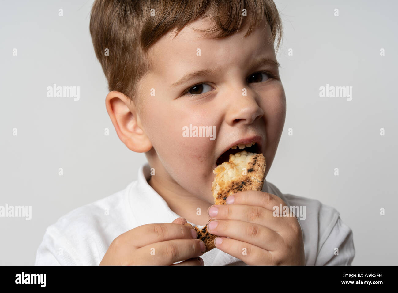 Cute boy eating pizza at home. Pizza at school. Enjoying his food Stock ...