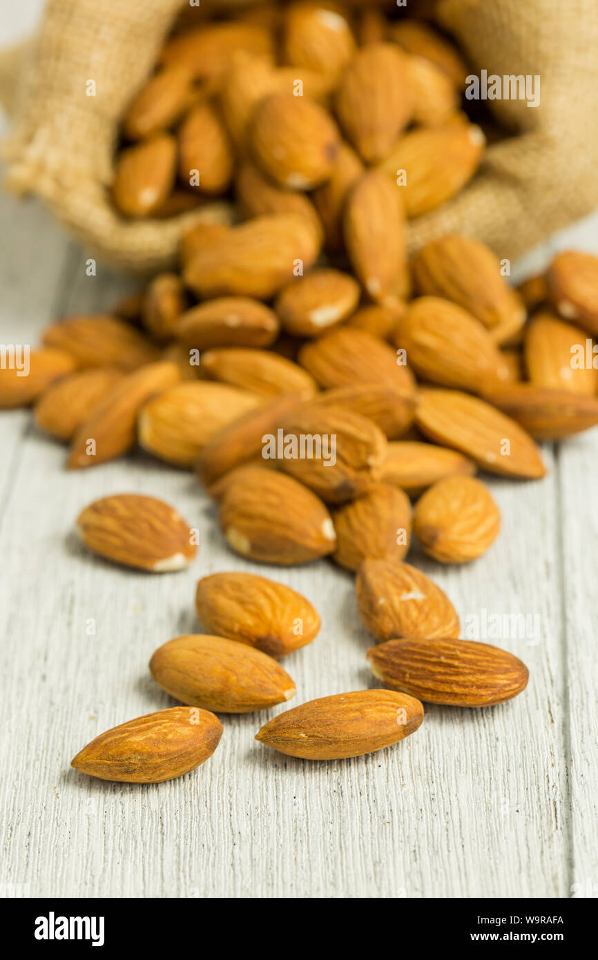 almond on white wood table Stock Photo - Alamy
